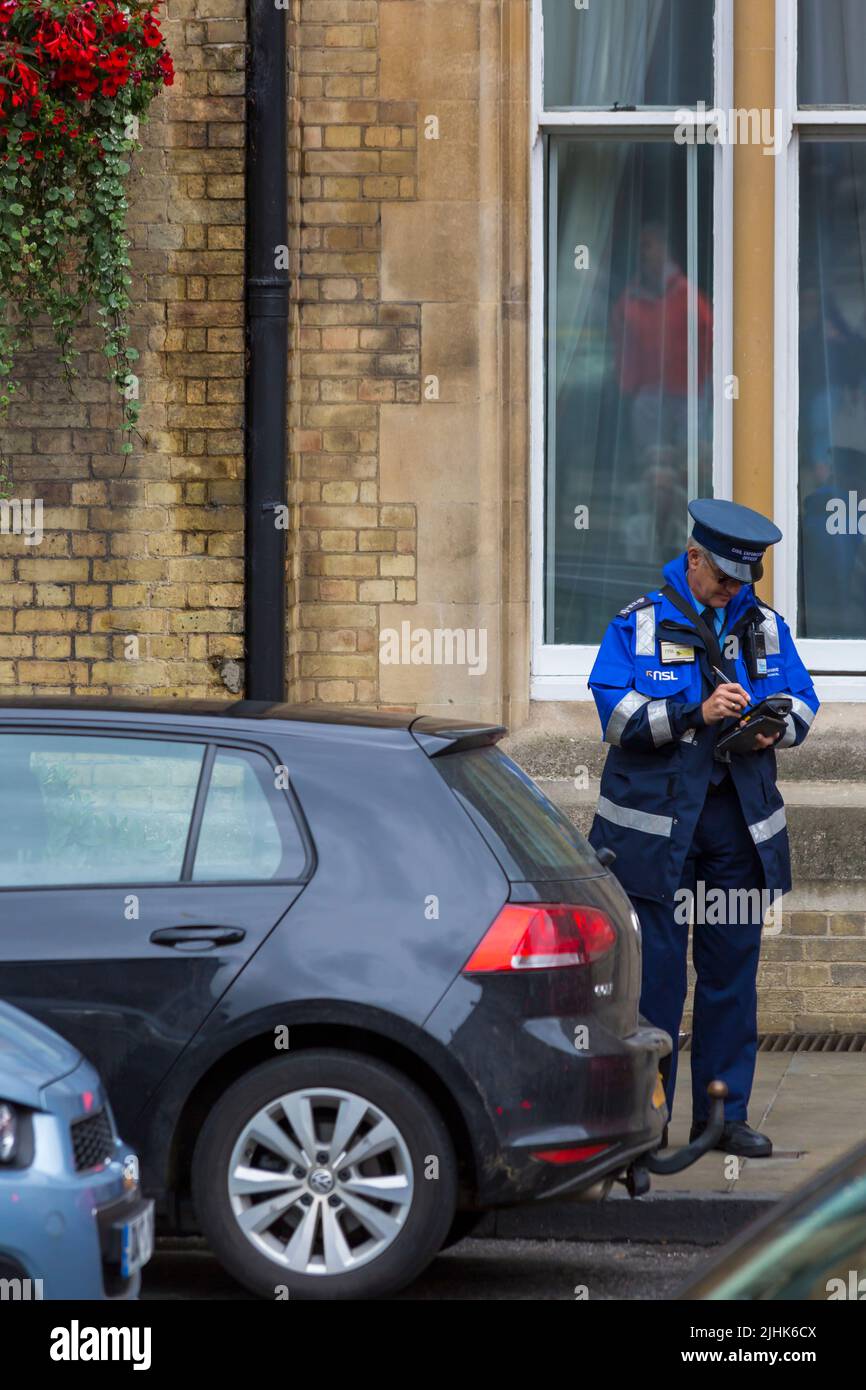 Civil Enforcement Officer on street checking parked cars at Oxford ...