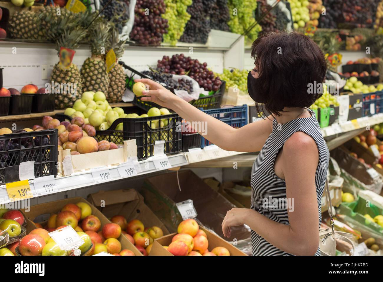 Woman buyer chooses apricots in the store Stock Photo - Alamy