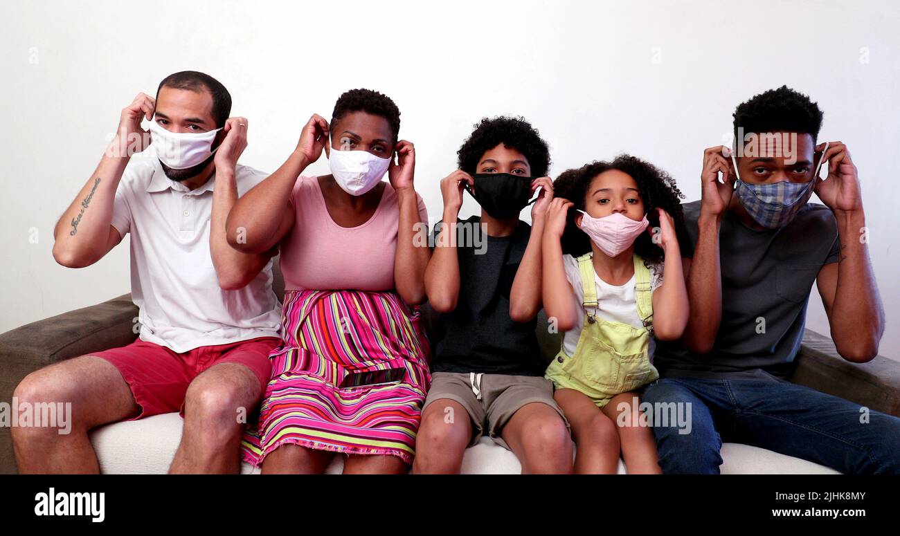 Family putting covid face mask together, interracial parents and ...