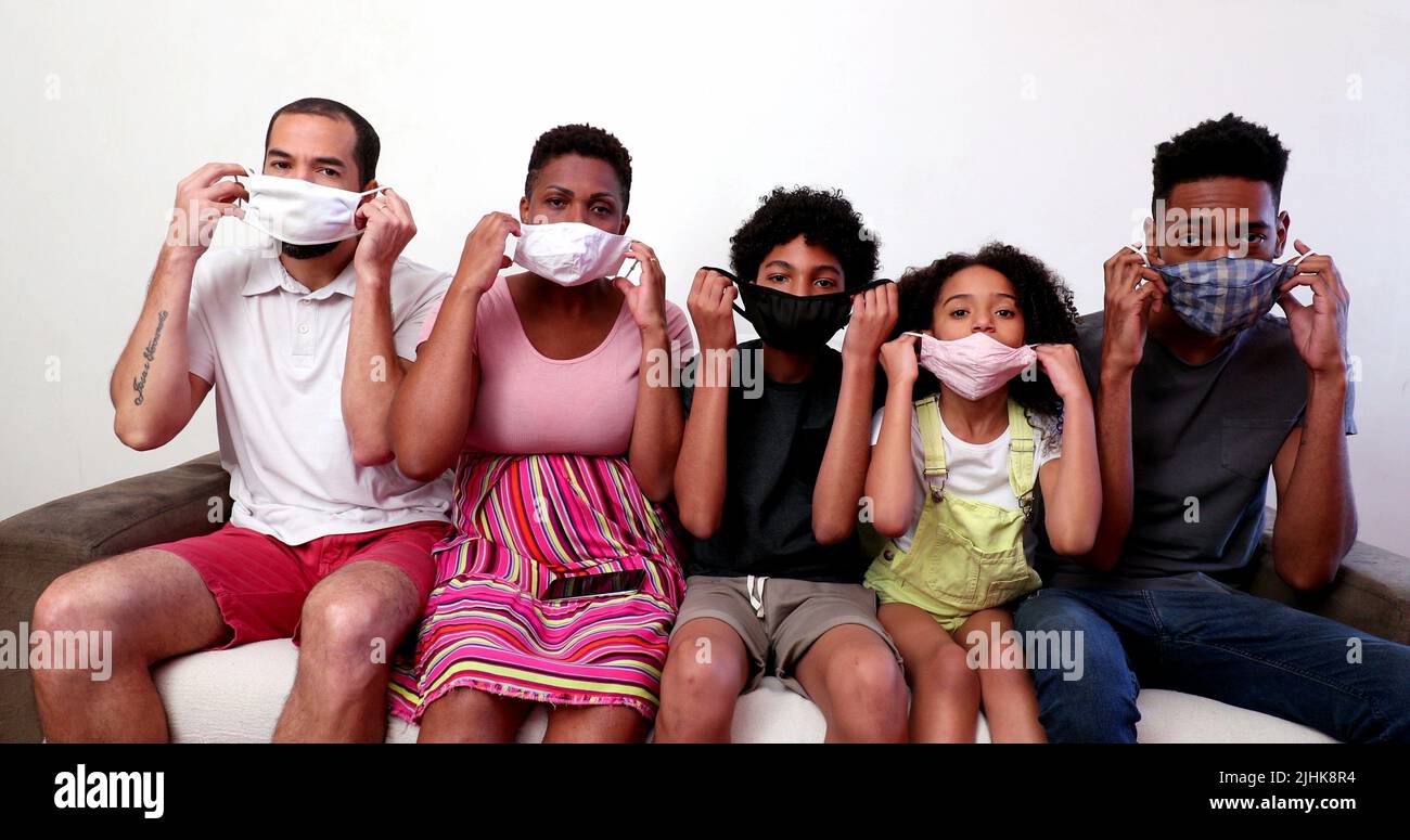 Family putting covid face mask together, interracial parents and ...