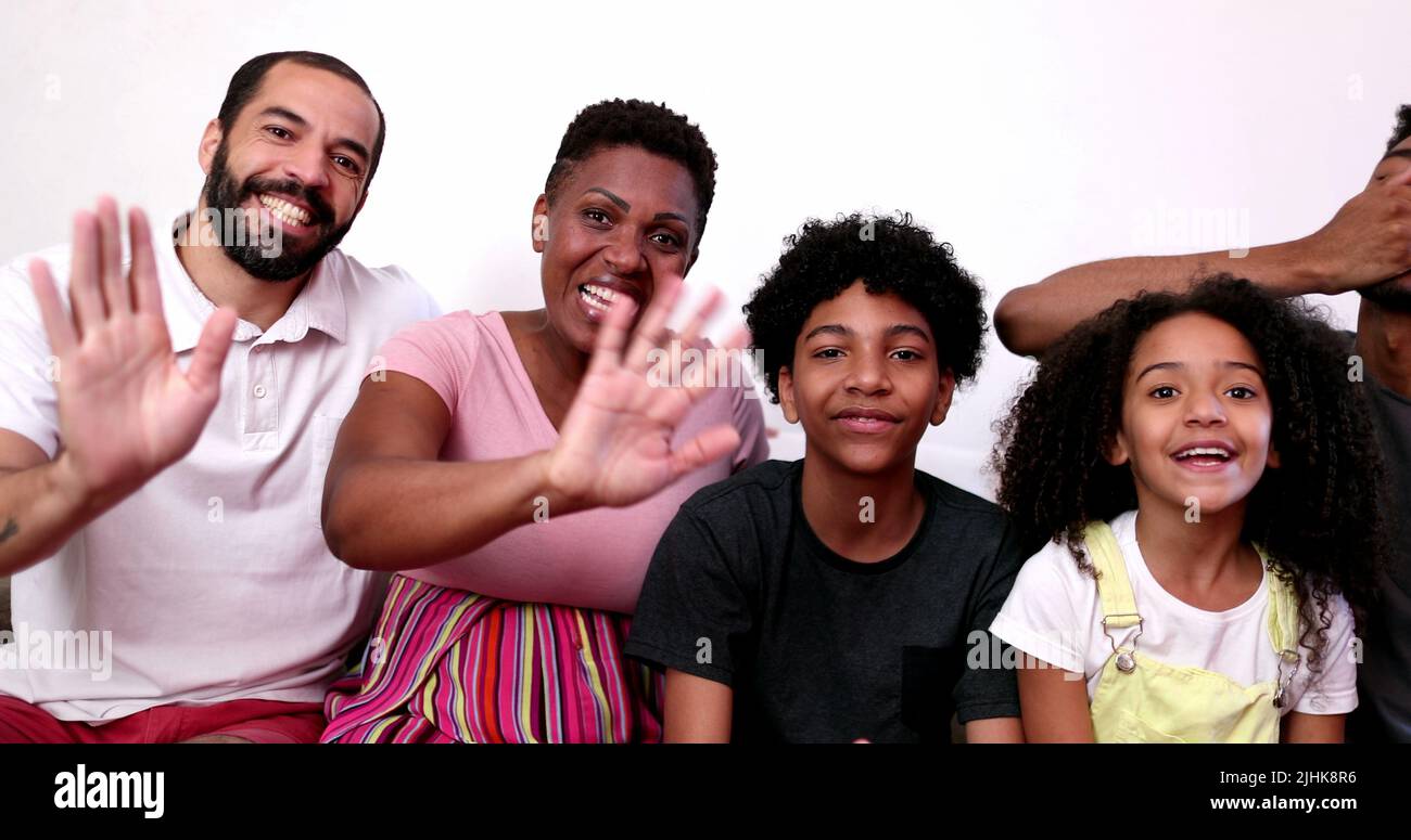Family waving hello to camera speaking video conference POV Stock Photo ...