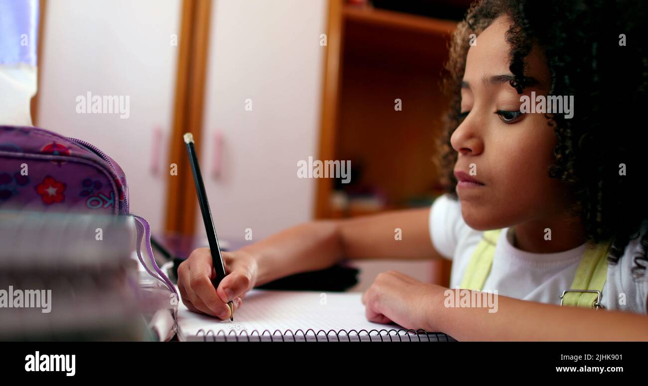 Focused little girl child writing notes on notepad Stock Photo - Alamy