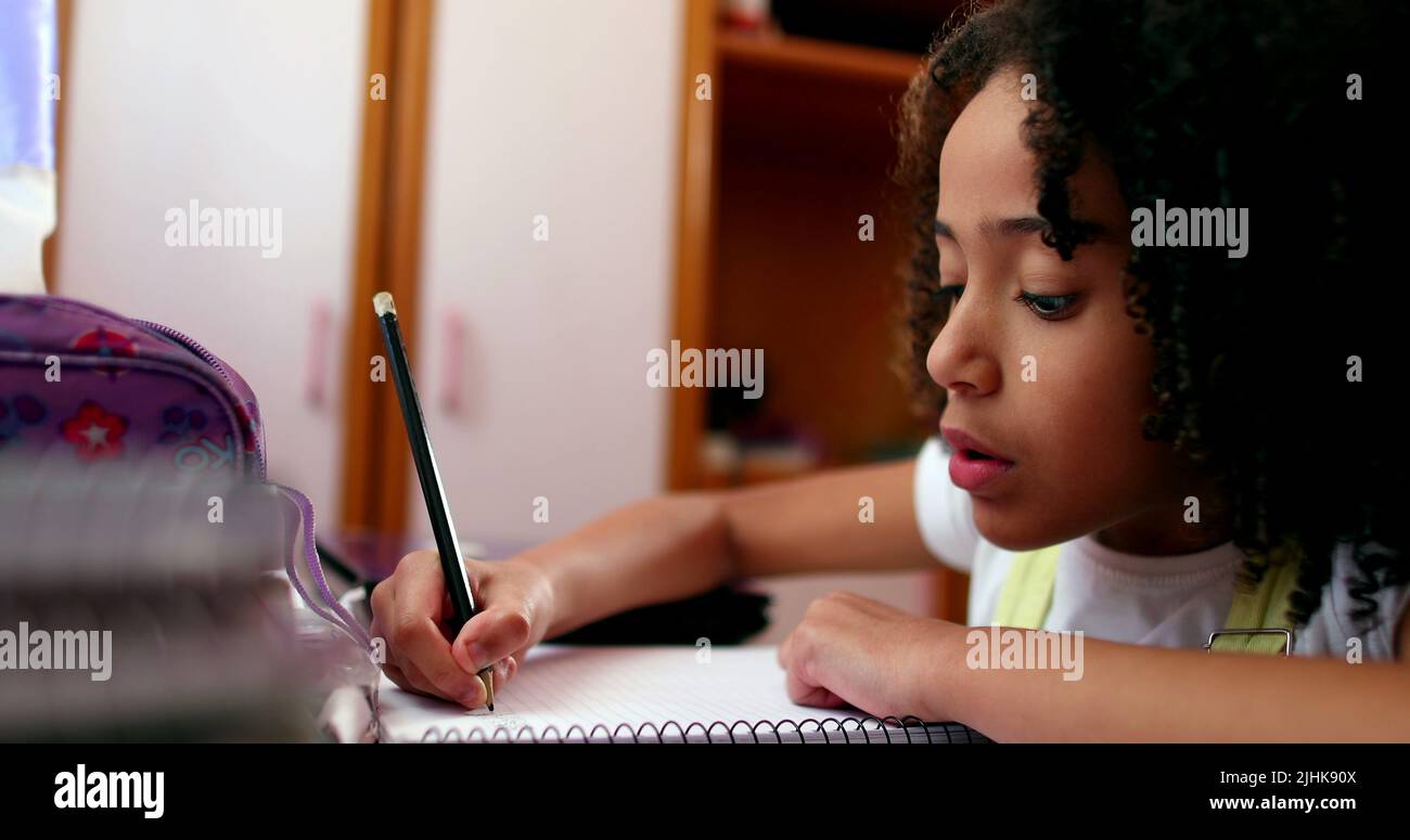 Focused little girl child writing notes on notepad Stock Photo - Alamy