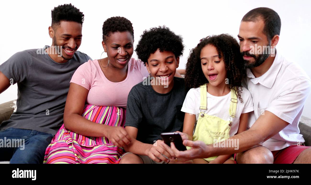Happy African interracial family holding smartphone. Parents and kids ...
