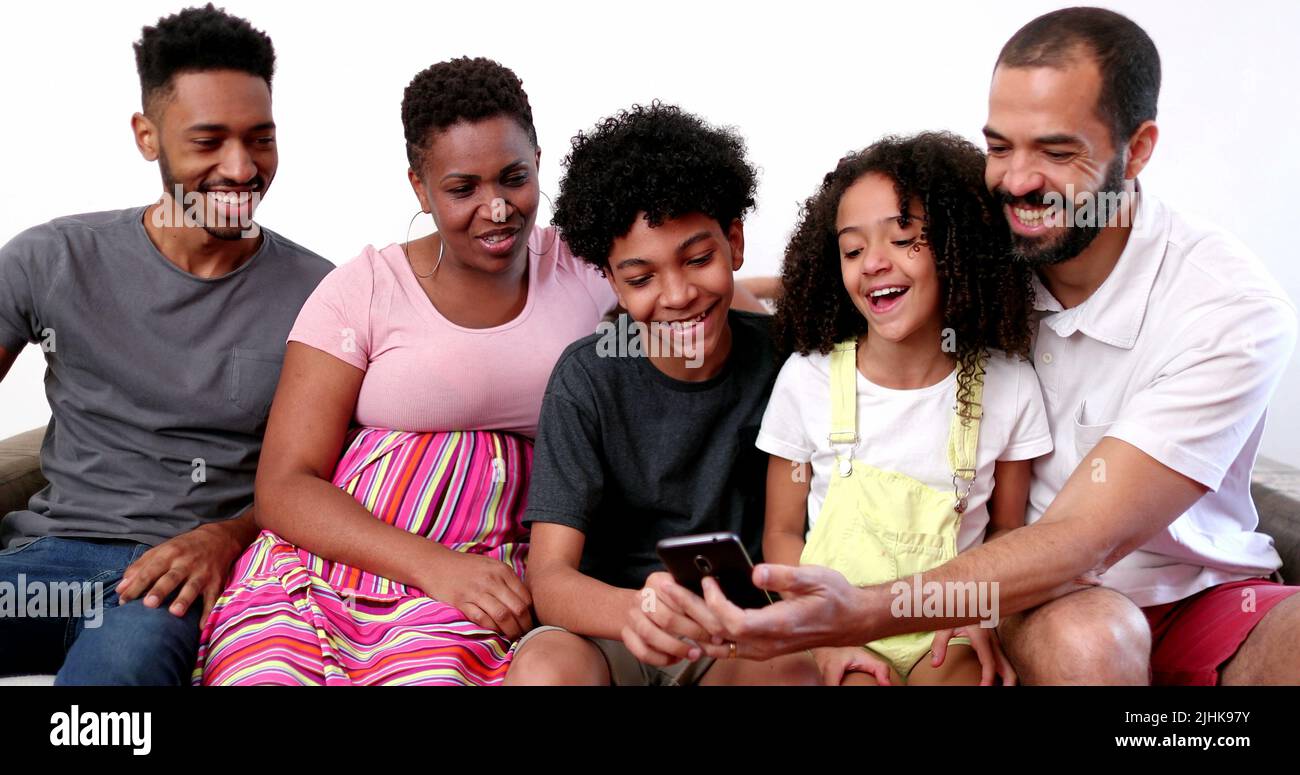 Happy African interracial family holding smartphone. Parents and kids ...