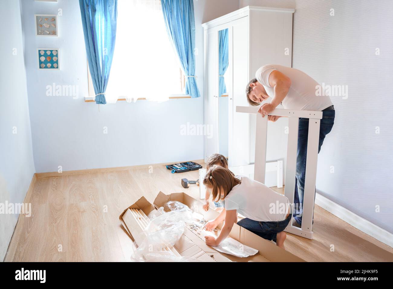 Dad,little girls daughters assemblle wooden baby bed according to ...