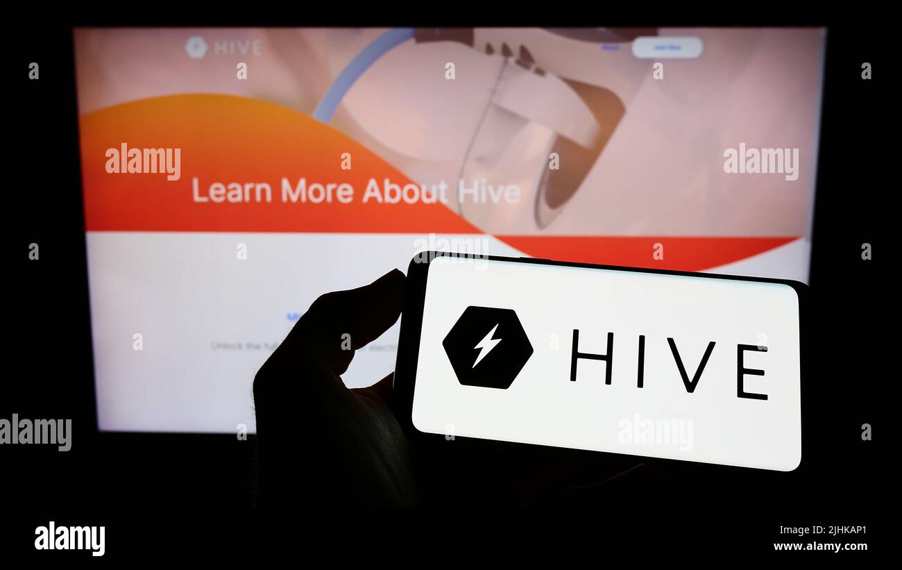 Person holding cellphone with logo of American company Hive ...