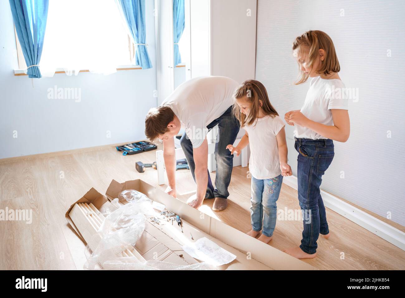 Dad,little girls daughters assemblle wooden baby bed according to ...