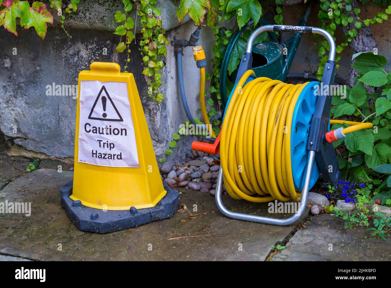 Caution trip hazard cone and hose pipe on reel at Oxford, Oxfordshire ...