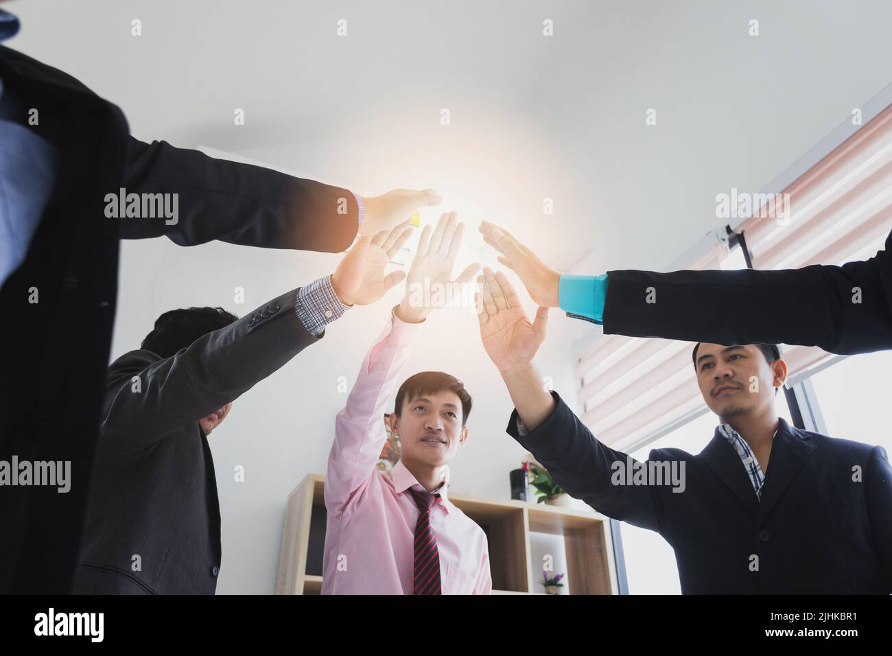 Concept of teamwork: Close-Up of hands business team showing unity with putting their hands ...
