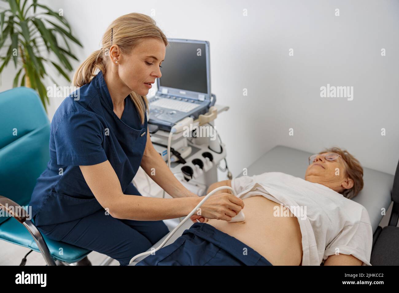 Doctor ultrasound examine senior patient abdomen at hospital. Prenatal ...