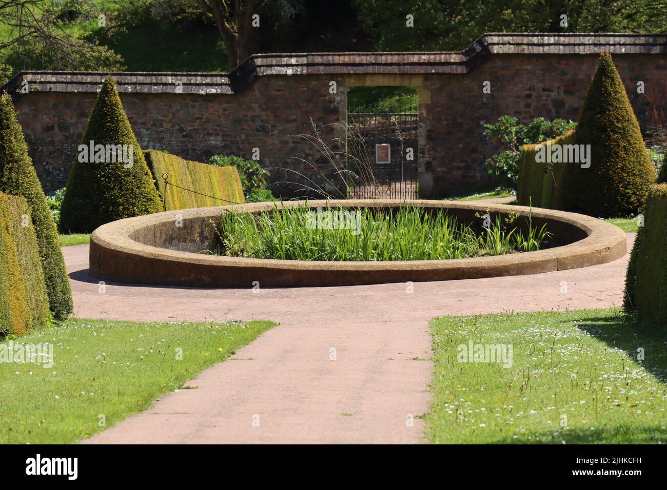A gravel pathway leads down to a circular pond in the kitchen garden of ...