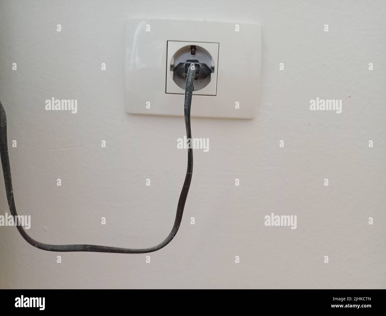 Black Cable Of Some Electricity Powered Machine Plugged Into Wall ...