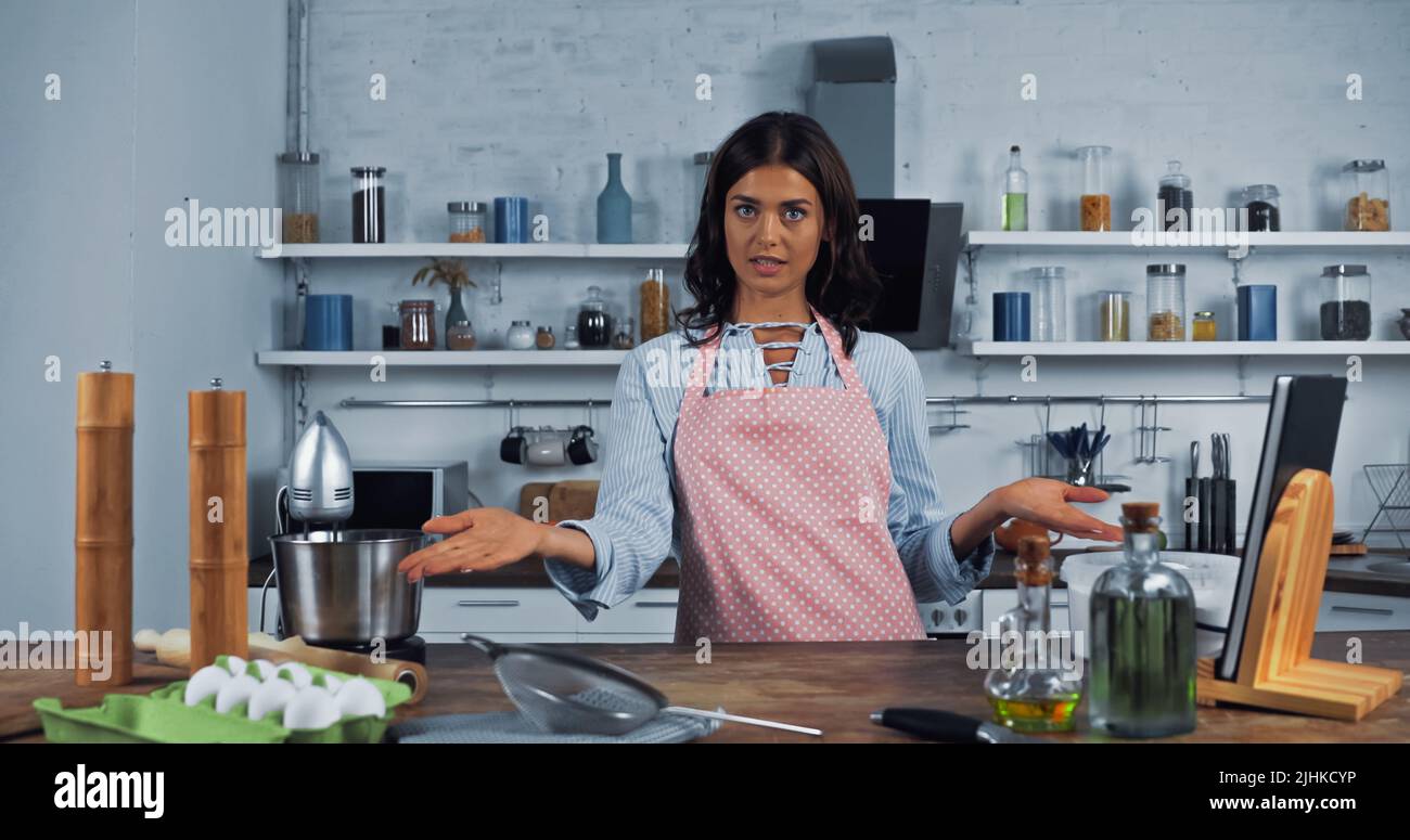 culinary vlogger pointing at ingredients and cooking utensils while ...