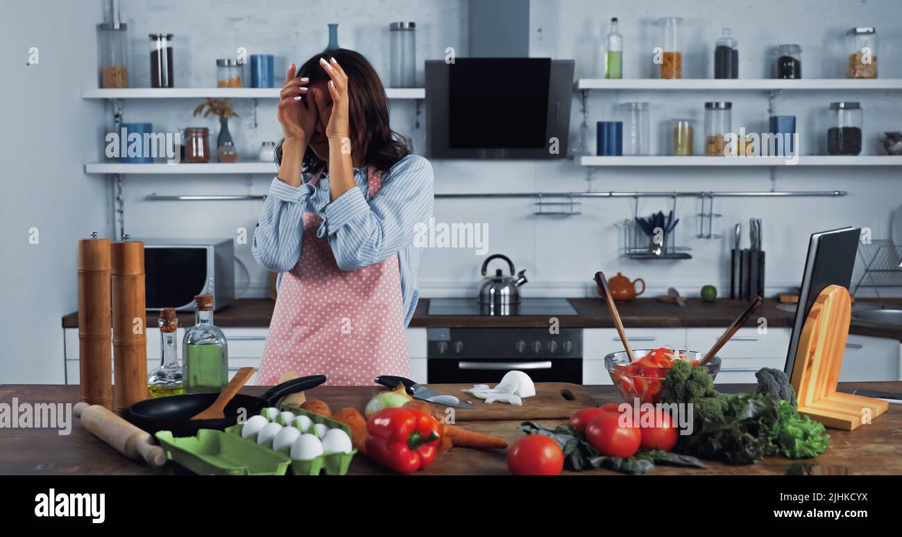 woman wiping irritated eyes near chopped onion on chopping board Stock ...