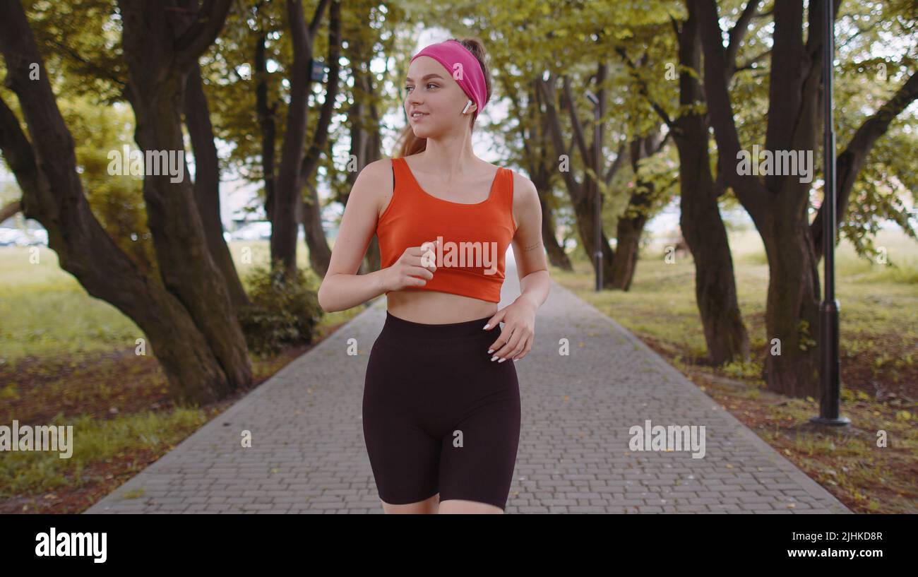 Athletic fit sport runner girl training marathon run, listening music ...