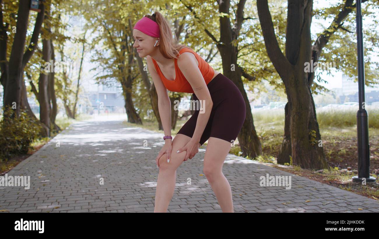 Athletic fit runner girl with muscle pain. Young woman massaging ...