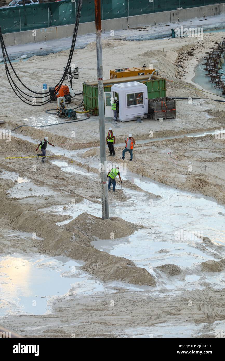 Construction site, worker crew drilling a hole with heavy bore machine ...