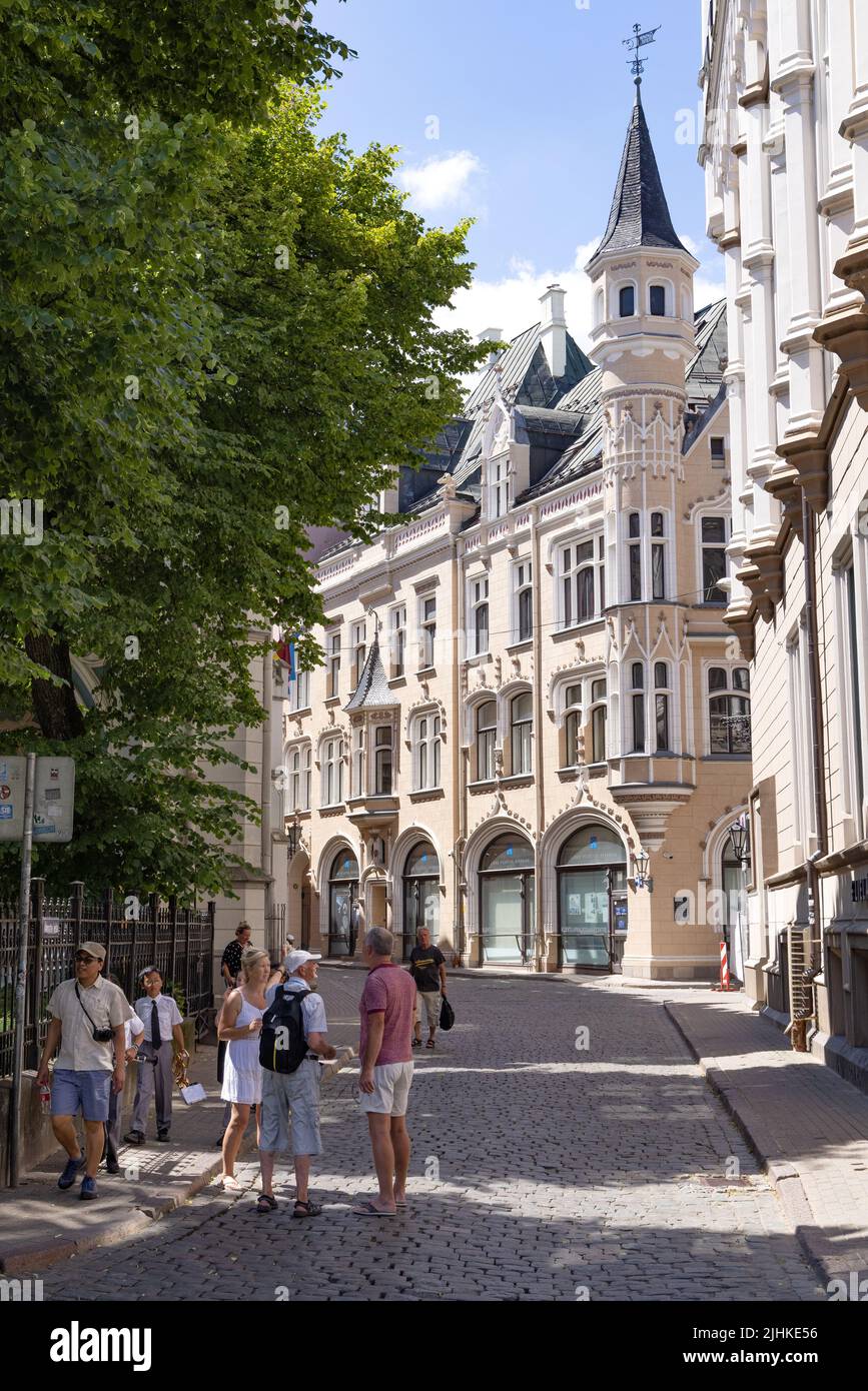 Riga street scene; Tourists walking cobbled streets admiring the ...