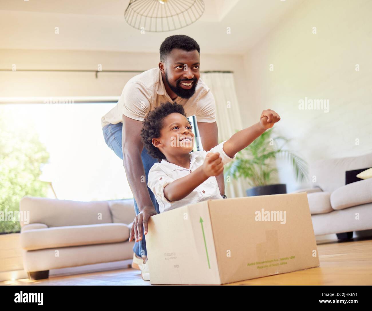 Driving his imaginary car, powered by dad. a father pushing his son in ...