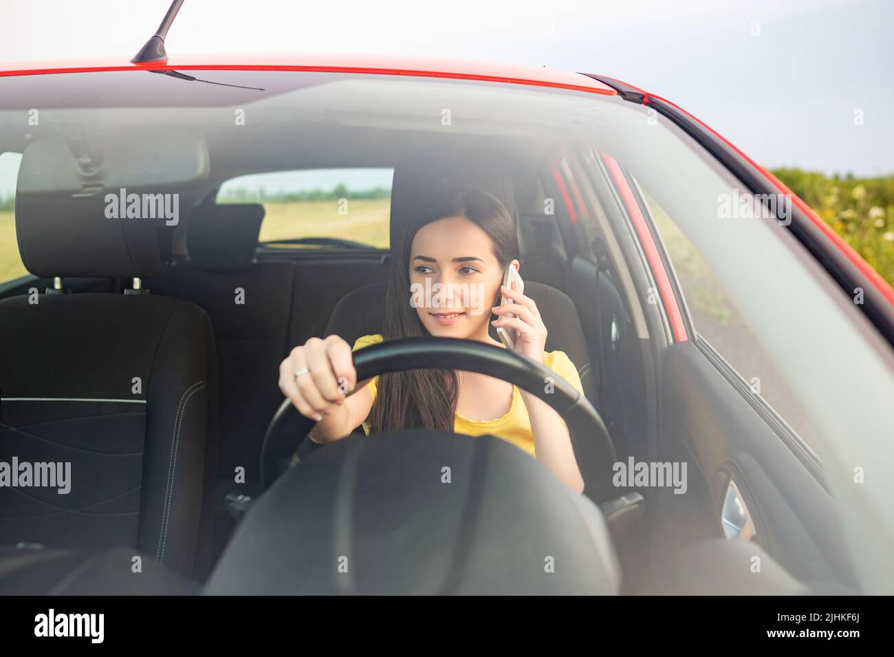 Woman is using a smartphone while driving a car Stock Photo - Alamy