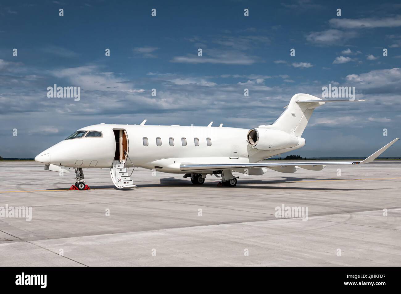 Modern white corporate business jet with a lowered gangway door at the ...