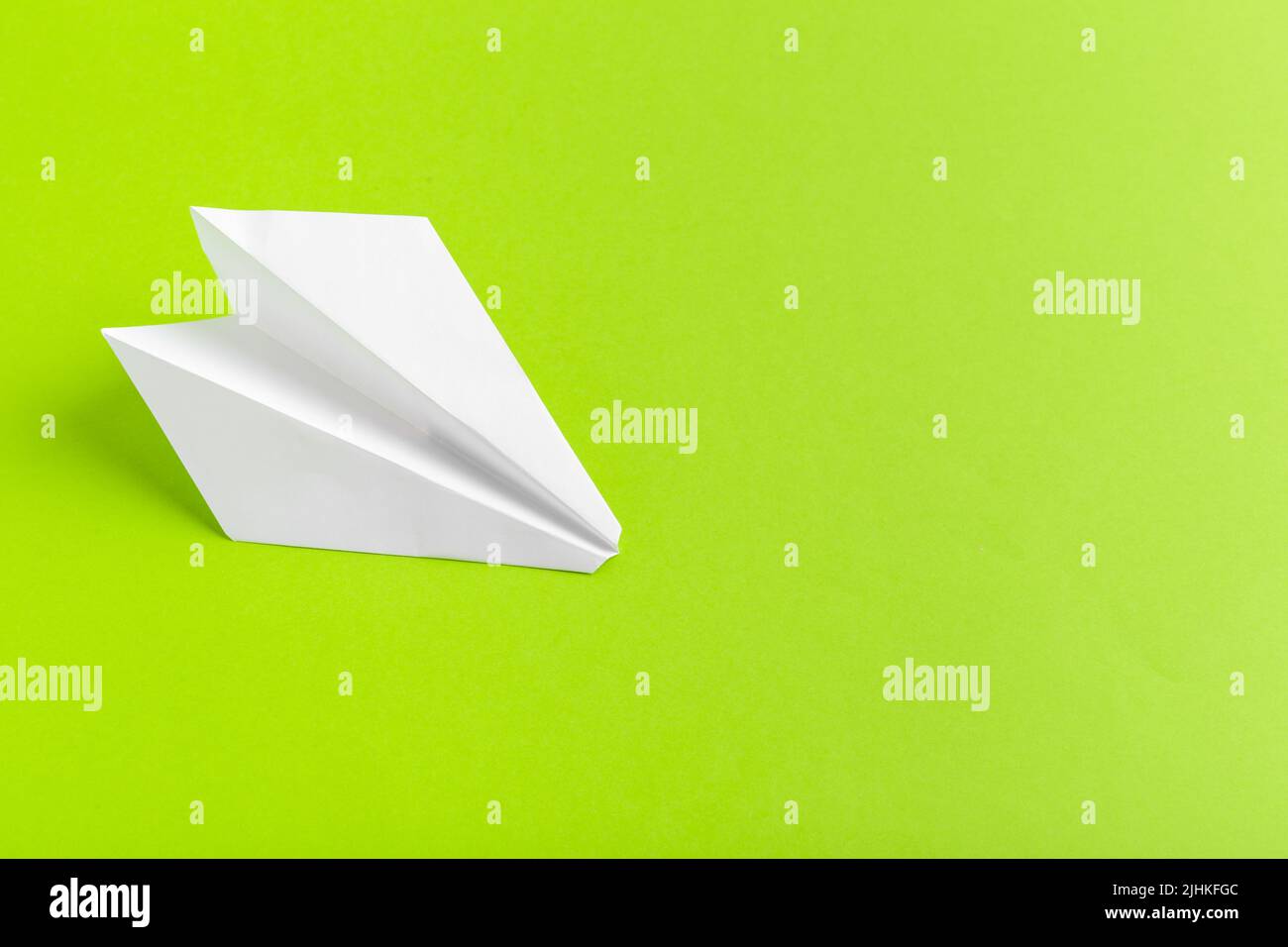Flat lay of a paper plane on green pastel color background Stock Photo ...
