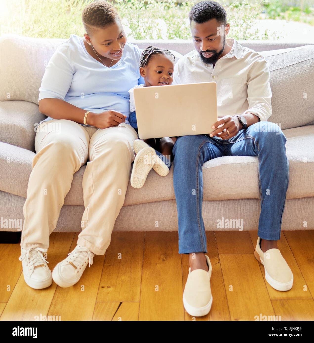 Just relaxing with the family. a family using a laptop together at home ...