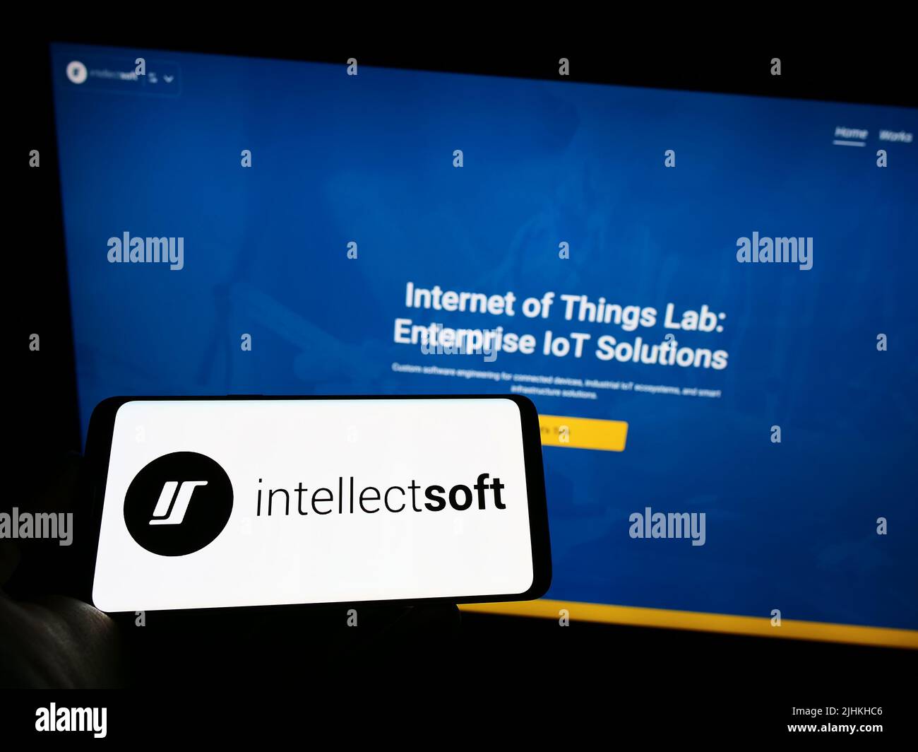 Person holding cellphone with logo of US software company Intellectsoft ...