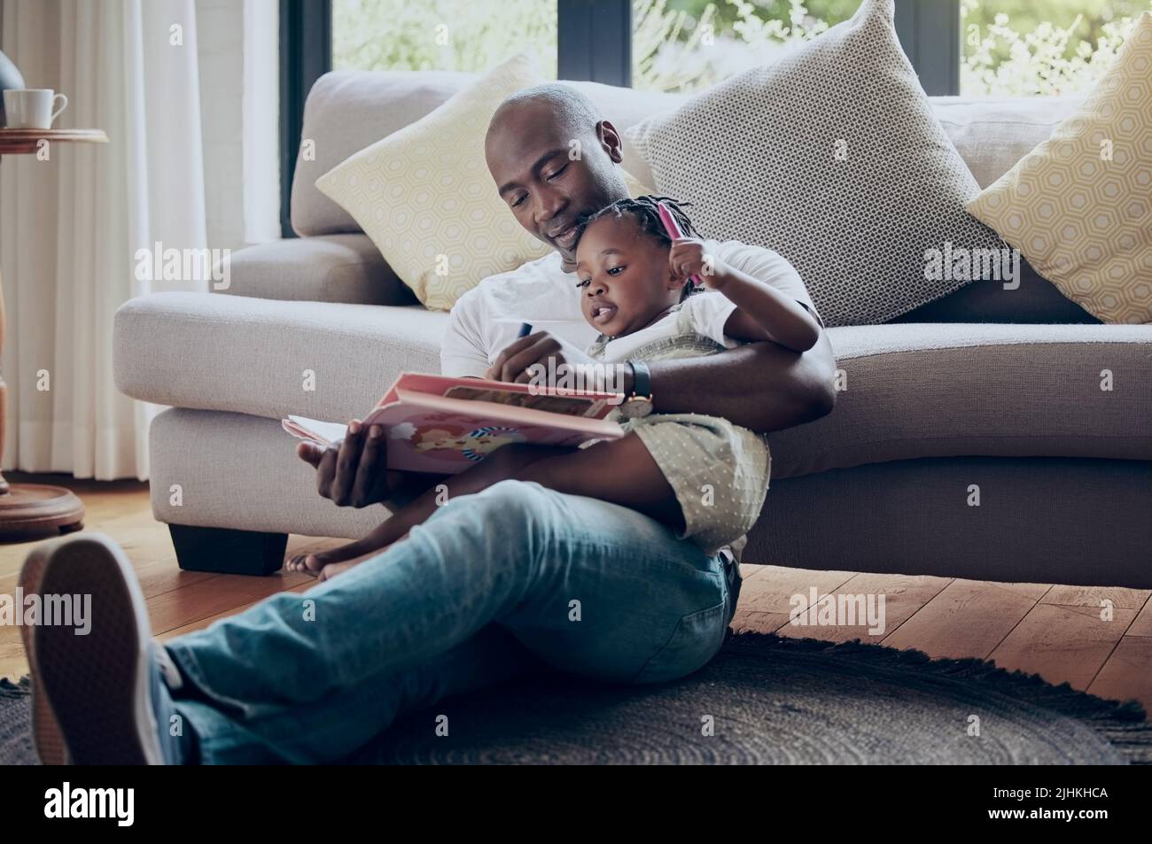 Getting creative. a father drawing in a book with his daughter at home ...
