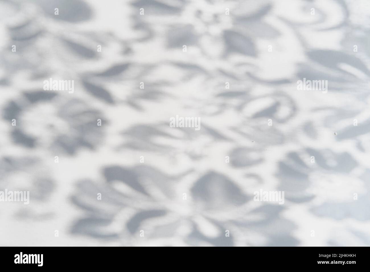 Gray blurred shadows of lace fabric with floral pattern as abstract ...