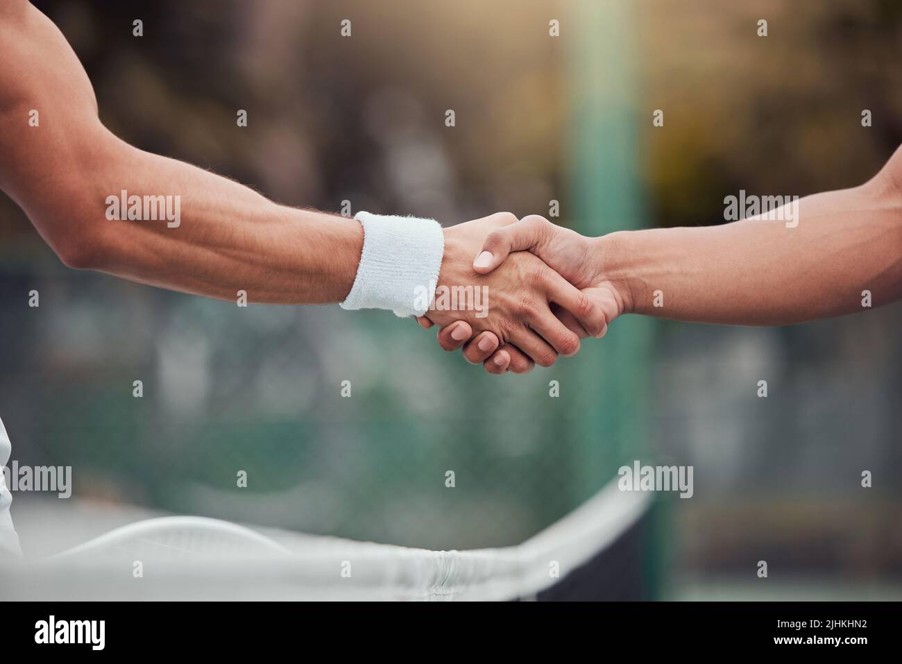 Two unknown ethnic tennis players shaking hands before playing court ...