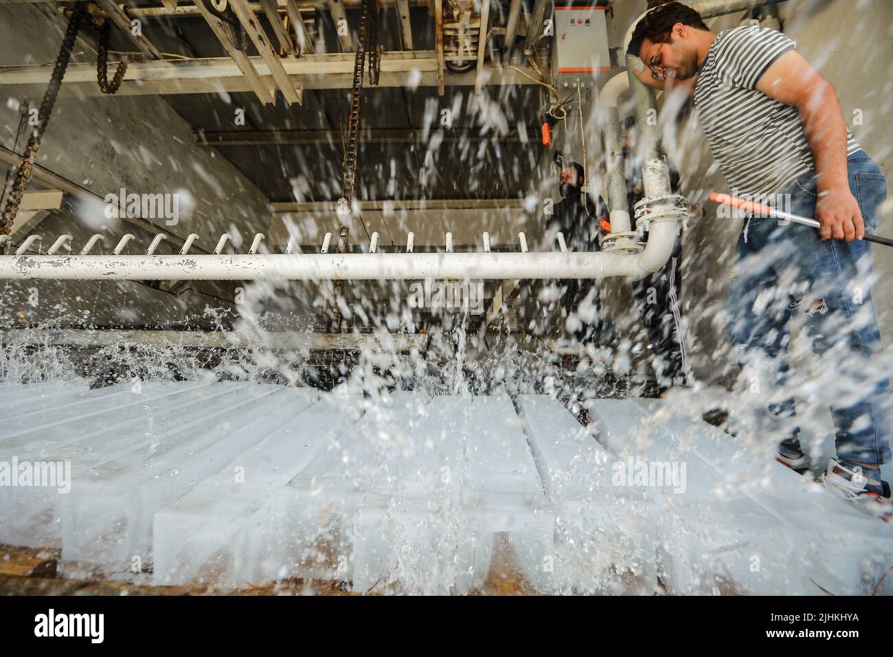 Baghdad, Iraq. 19th July, 2022. Workers prepare ice blocks at a local ...