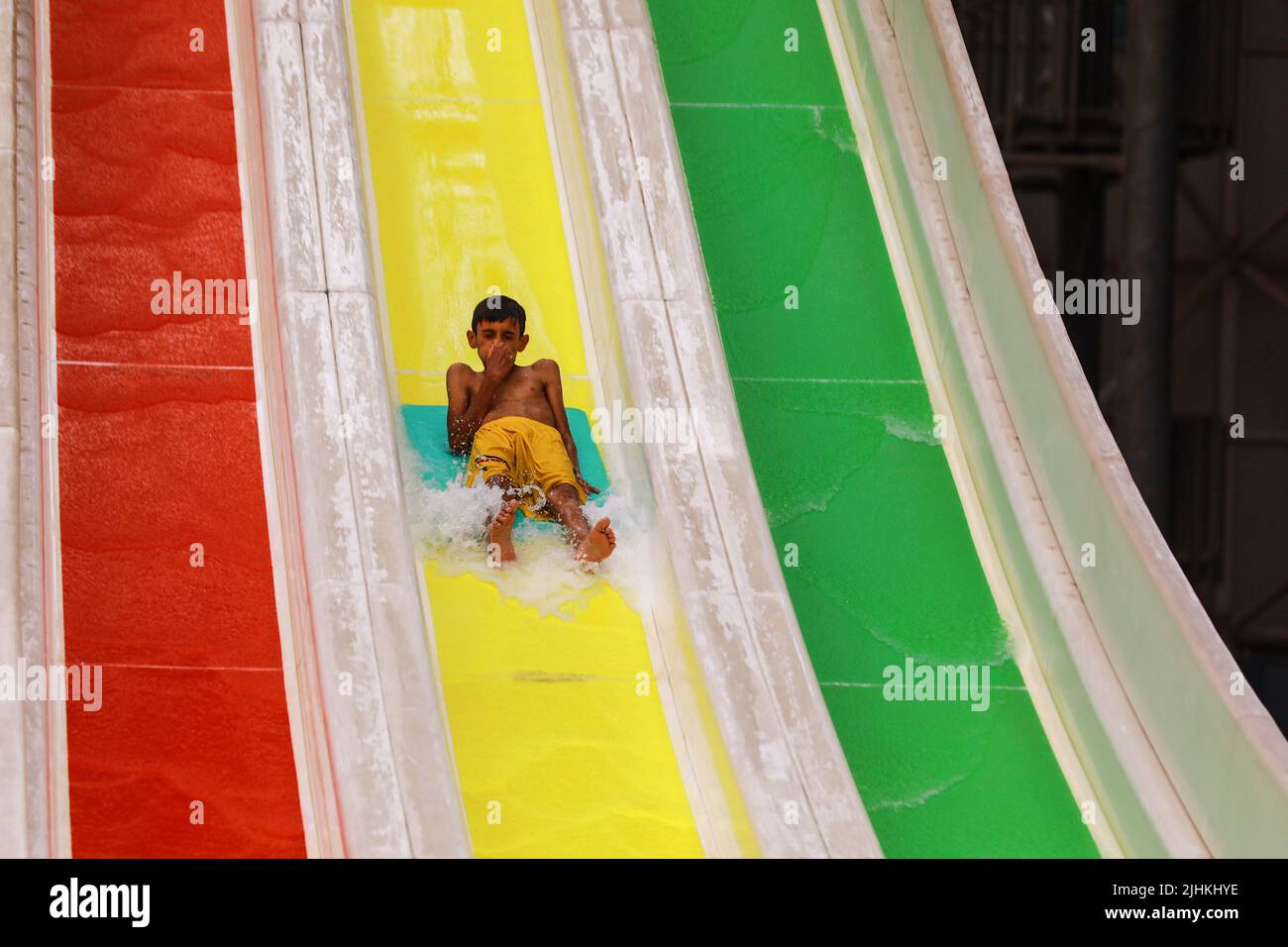 Baghdad, Iraq. 19th July, 2022. A Iraqi boy goes down a water slide at ...