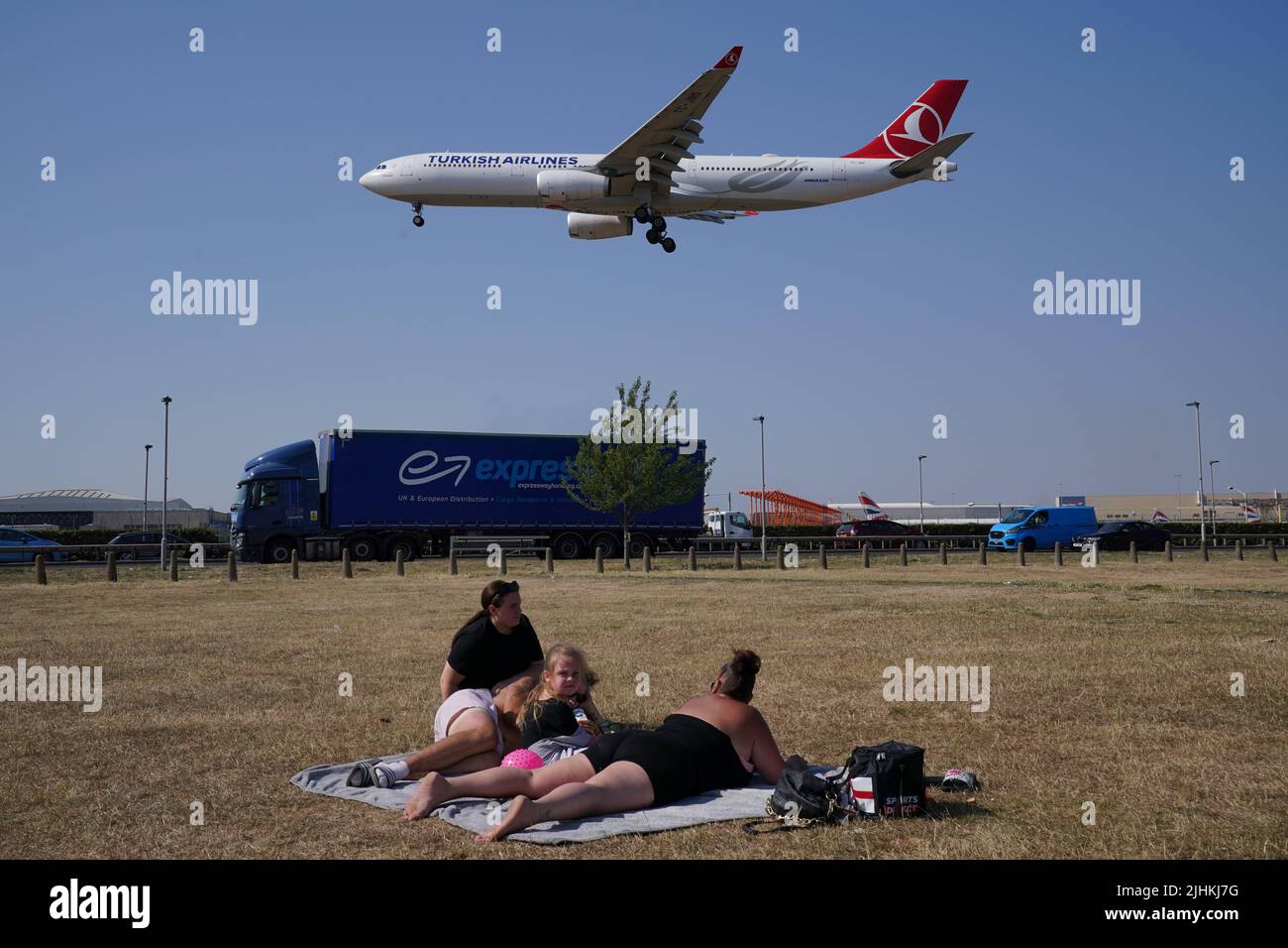 People enjoy the hot weather in a field beneath a Turkish Airlines ...