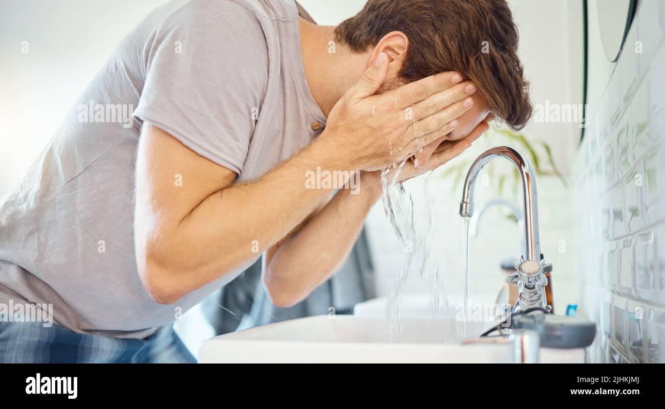 One handsome man washing his face in a bathroom at home. Caucasian male ...