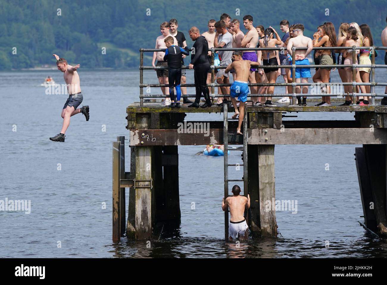 People diving off the pier at Loch Lomond, in the village of Luss in ...
