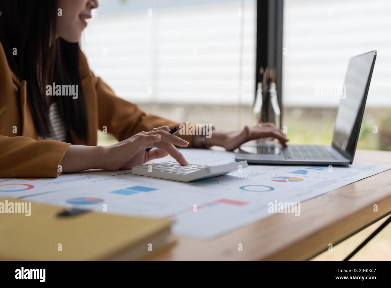 Businesswoman press the white calculator to calculate the numbers in ...