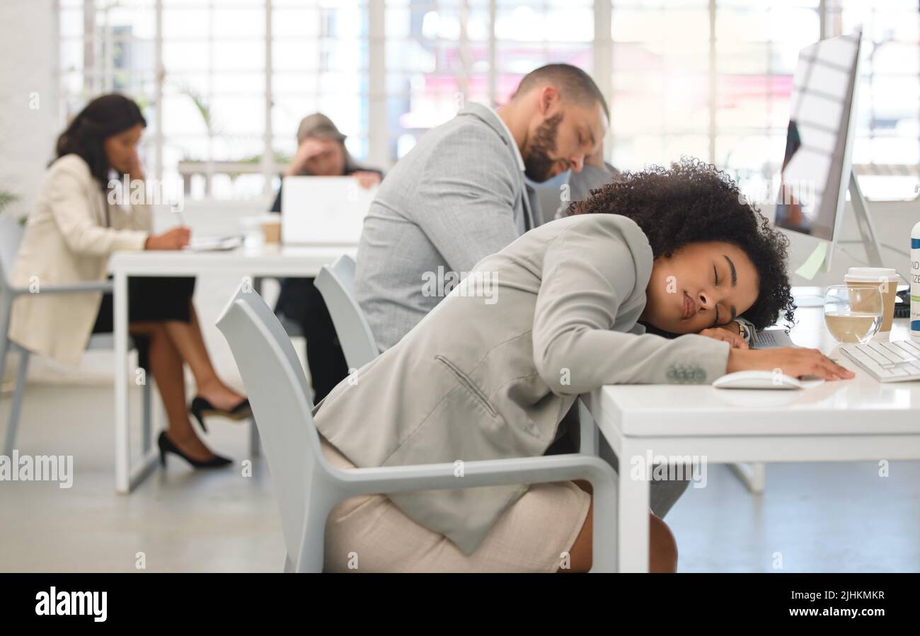 Two young mixed race call center agents sleeping at their desks while ...