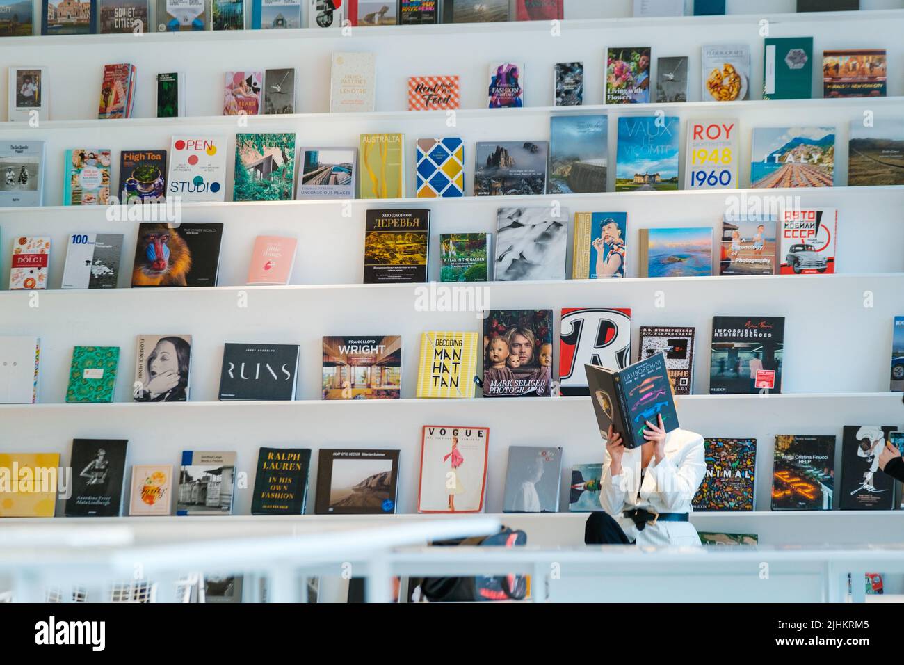 Anonymous woman reading book in library Stock Photo - Alamy
