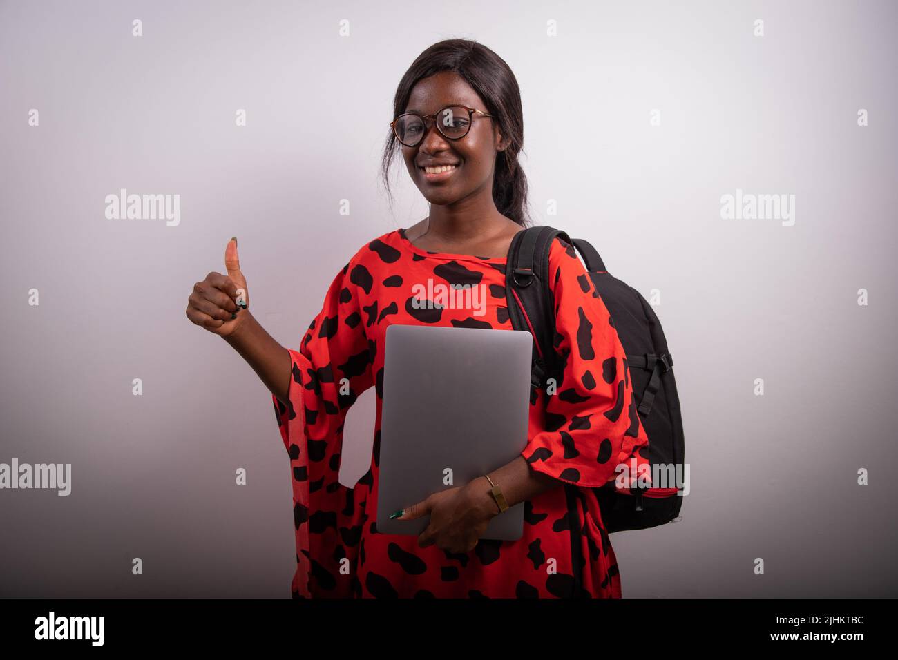 Thumb up, young student passed her exam with a good grade and is happy ...