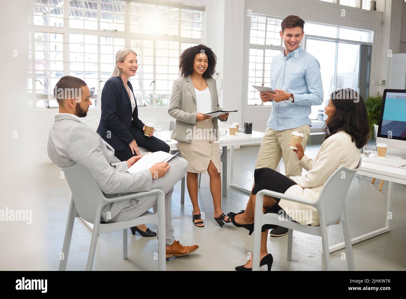 Group of five diverse businesspeople having a meeting in an office at ...