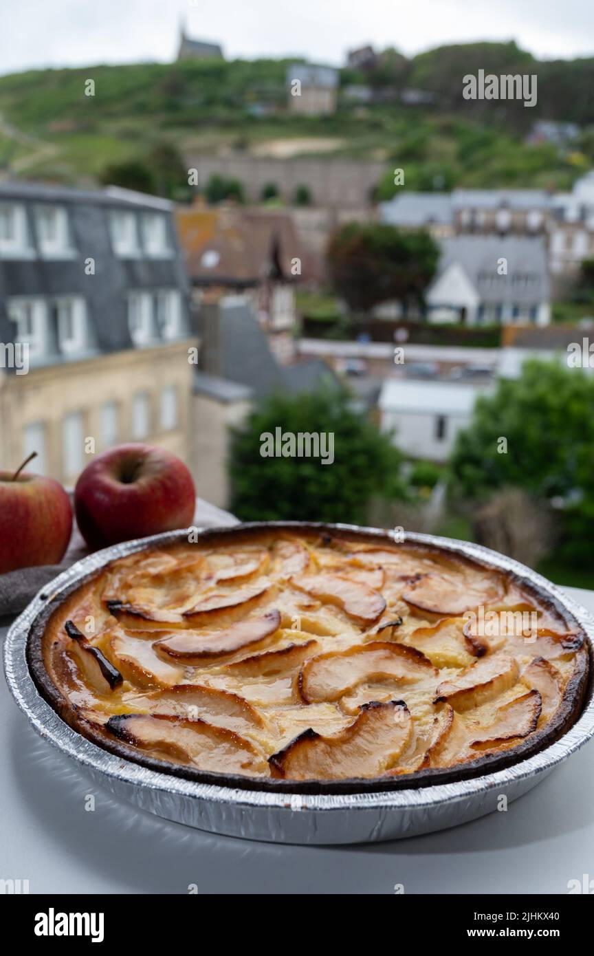 Tasty sweet French dessert, baked apple cake and view on old houses of ...