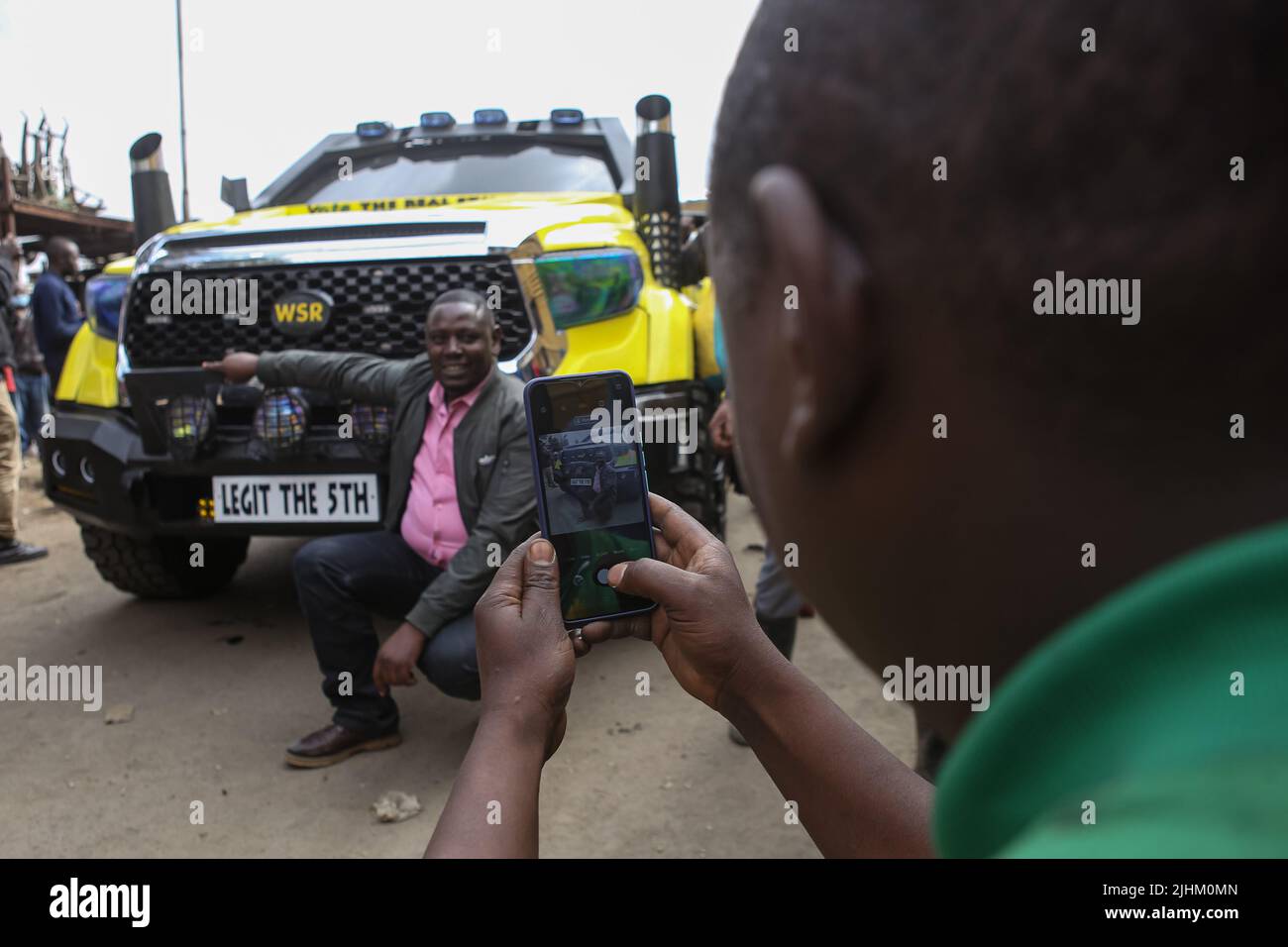 A Kenyan man poses for a photo in front of a rally-truck during a ...