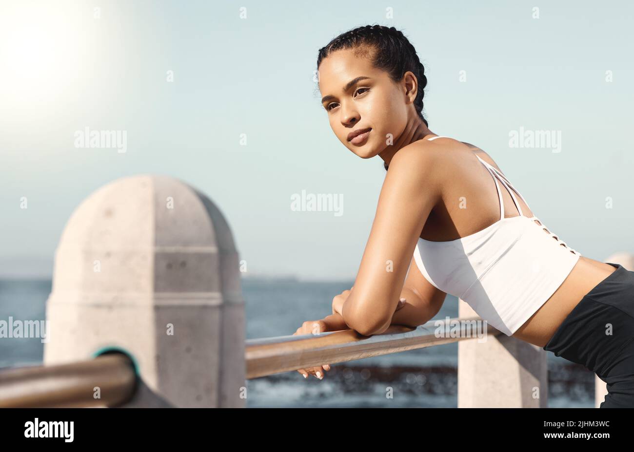 Fit young hispanic female athlete in sportswear taking a break from her ...