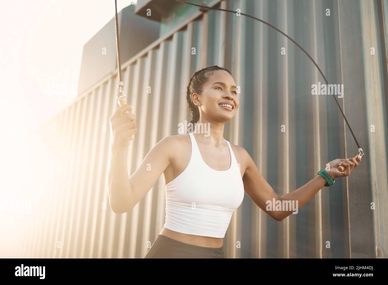 One fit young hispanic woman skipping with a rope while exercising in ...