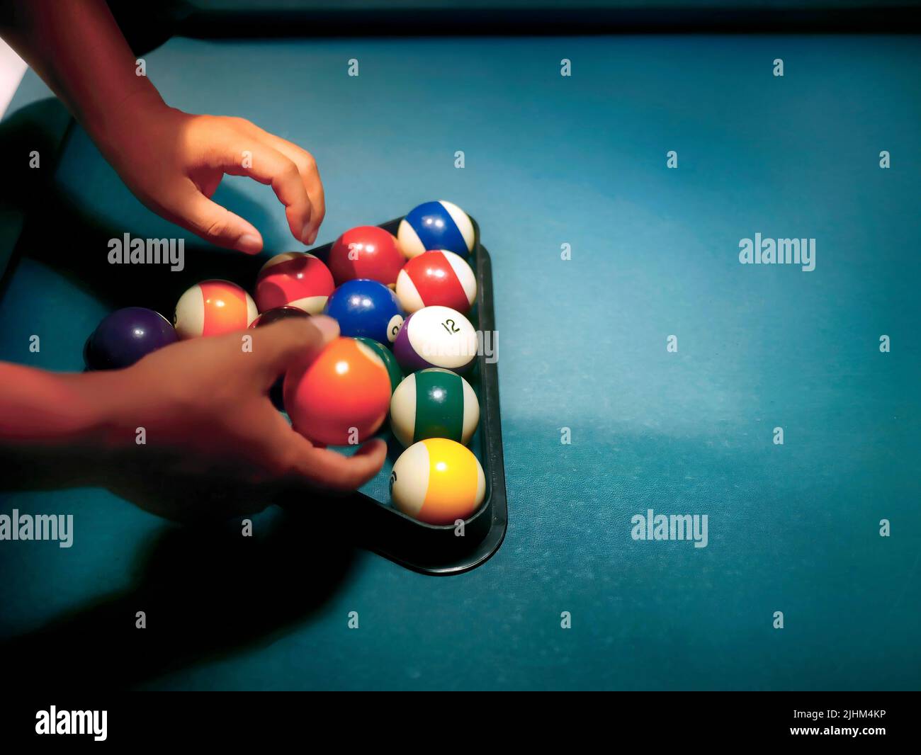 Hands preparing pool balls in triangle rack on the billiard table Stock ...