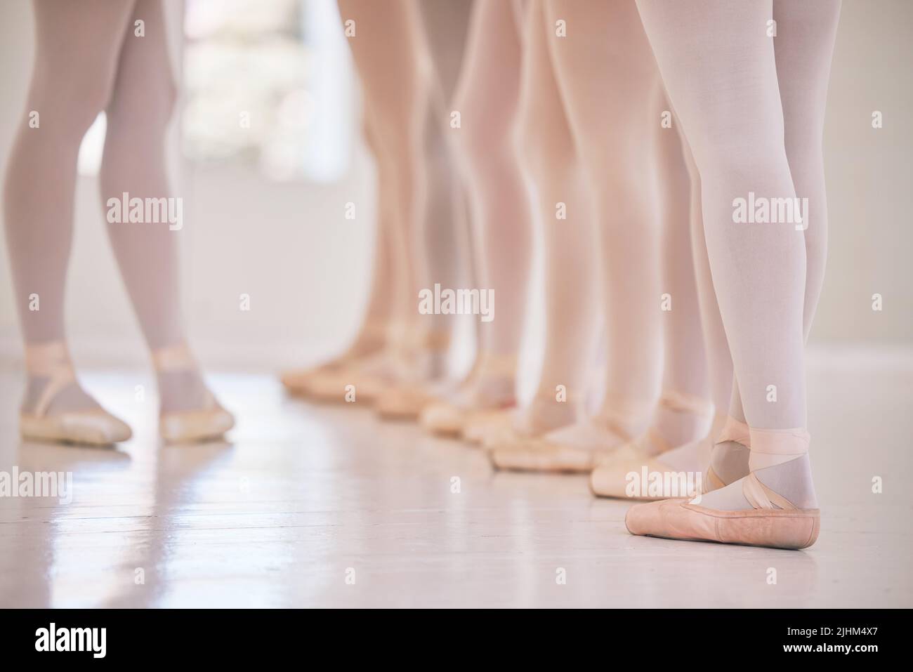 Closeup woman dance instructor teaching a ballet class to a group of a ...