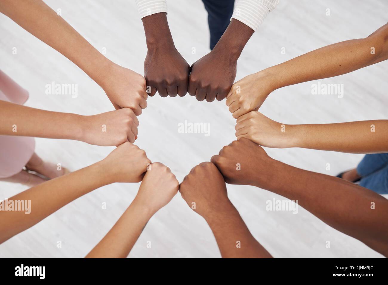 Closeup of a group of businesspeople giving each other a fist bump ...