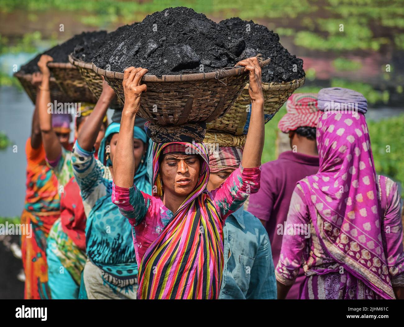 Women workers carrying baskets filled with coal on their head in the ...